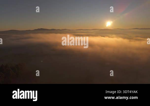 Aerial view of a sea of fog over morning countryside under clear sky ...