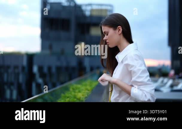 Depressed woman standing on the roof of a high-rise building looking ...