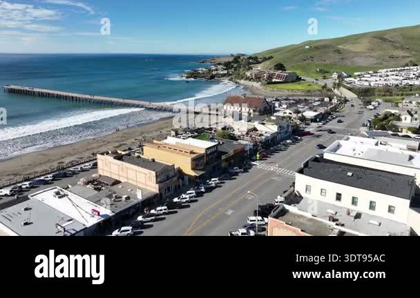 Wide aerial shot of Cayucos Pier, Pacific shoreline, tourists walking ...