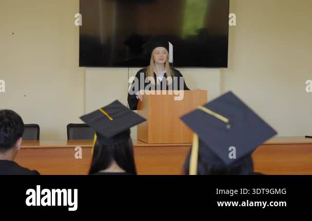 A young woman stands at the lectern and delivers a graduation speech to ...