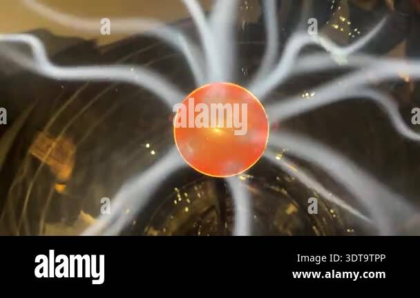 Luminous electric plasma filaments emanating from a central orange ...