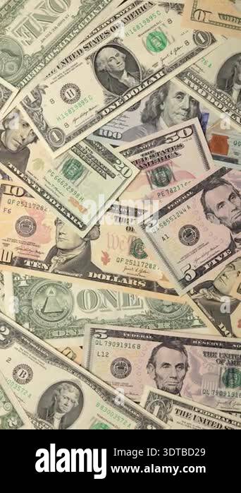 Top vertical view of rotating dollar bills, US currency as background ...