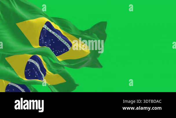 Brazil national flags waving in the wind isolated on green background ...