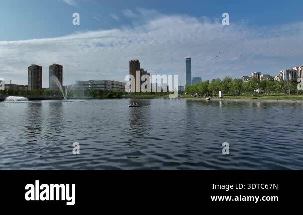Aerial perspective flying low over a tranquil urban lake, showing ...