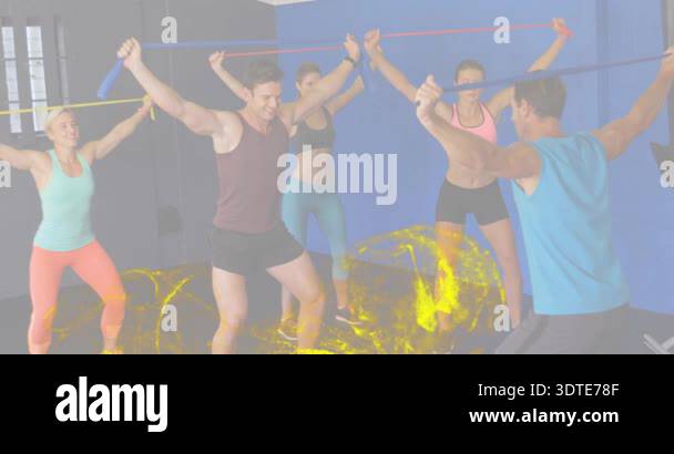 Coach cueing overhead band pull, fitness group squatting while yellow ...