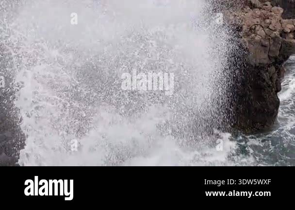 A beautiful view of a storm wave violently crashing and shattering into ...