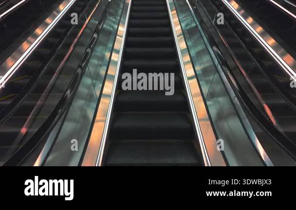 Close up of modern escalator stairs with metallic reflections and ...