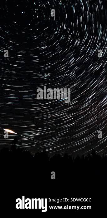 Circular star trails around pole over forest night sky long exposure ...