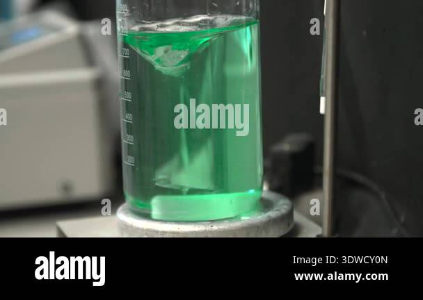 Beaker With Green Vortex Stirring Liquid In Closeup On Magnetic Stir ...