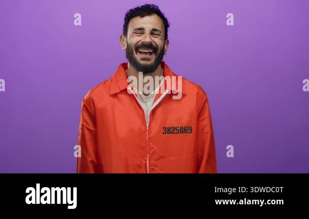 Hispanic man with beard in orange prison jumpsuit stands against a ...