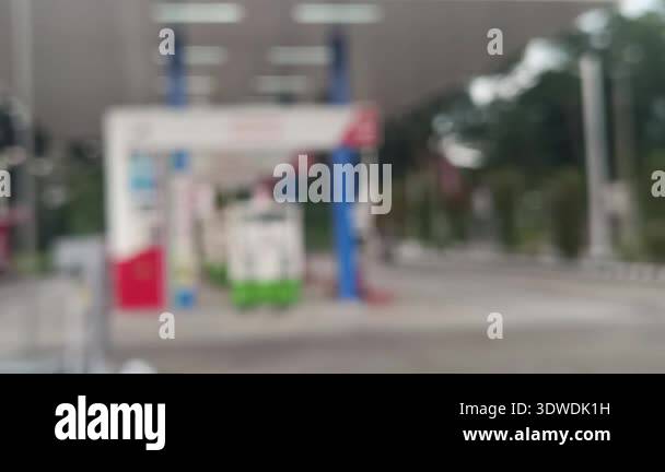 Out of focus view of a modern gas station, showing fuel pumps, a canopy ...