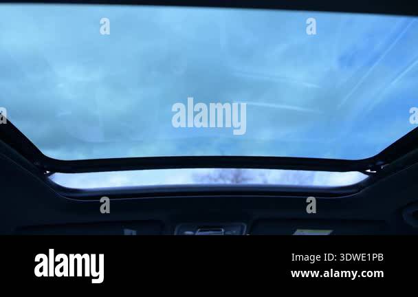 A cozy car interior reveals a vast stretch of blue sky and fluffy ...