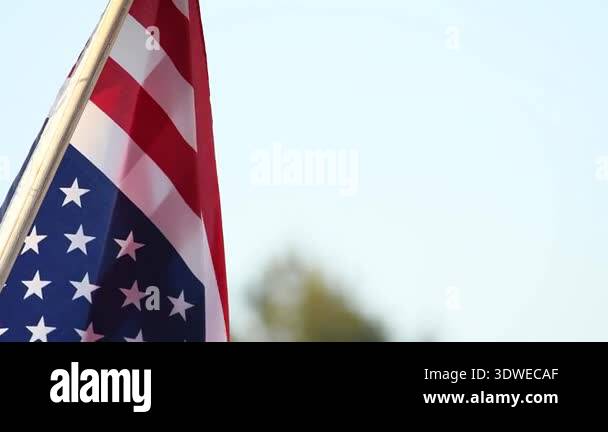 A close-up of the US flag fluttering in the setting sun, a patriotic ...