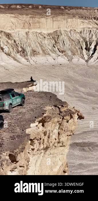 Aerial view of a solitary person meditating on the edge of a steep ...