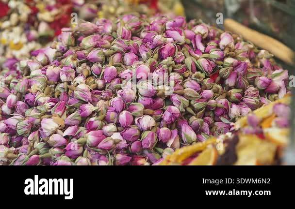 People look at dried rose buds in a market in Turkey. The sun shines ...