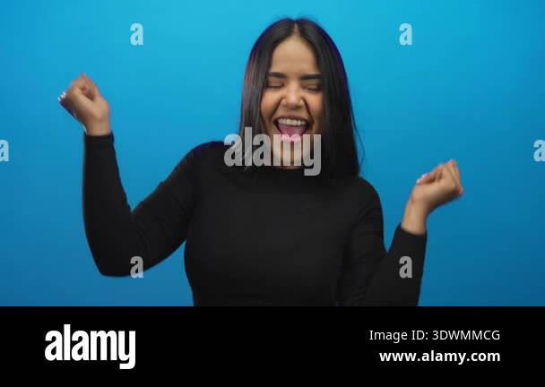 Woman celebrating joyfully in front of a vibrant blue background ...