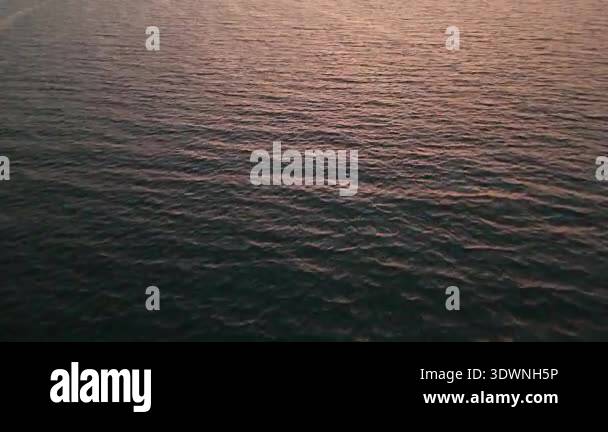 4K Aerial forward shot over calm sea water surface at sunset Stock ...