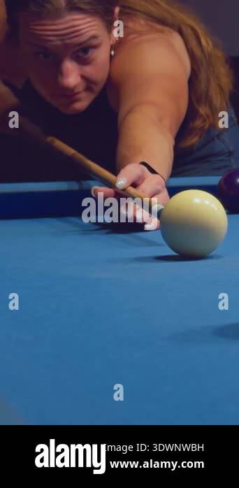 Vertical video. Woman Leaning Over Pool Table Aiming Cue At Cue Ball ...
