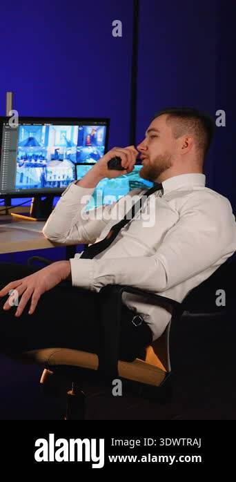 Male security officer sitting in a control room, monitoring ...