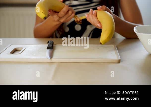 Cutting bananas for a recipe in a kitchen setting with a knife and ...
