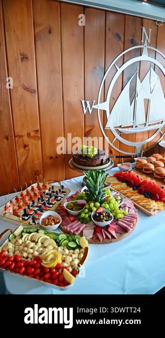 Catering buffet table with snacks and ship wall decor. Assorted ...