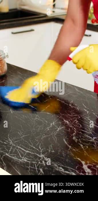 Arabian man wipes kitchen counter with cleaner and microfiber cloth ...