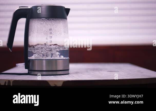 Hot water boiling in glass kettle wide 4k slow motion shot selective ...