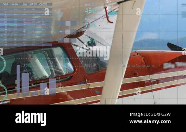 Male pilot monitoring flight metrics while view of red plane initiating ...