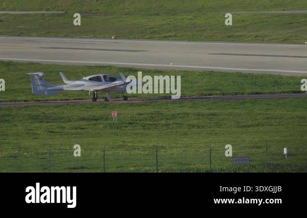 Small twin-engine aircraft taxiing on an airfield before takeoff on a ...