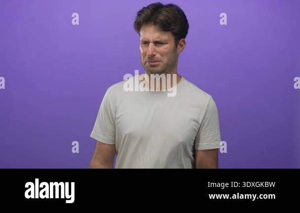 Man grimacing with hand on chest and pained squint, wearing tshirt ...
