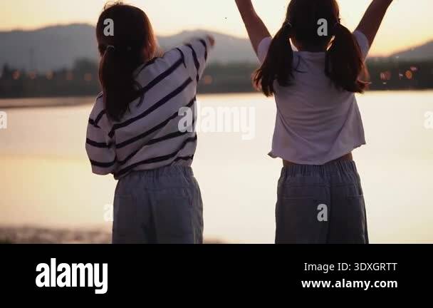 Happy Siblings Sharing a Peaceful Moment by the Lake at Sunset. Joyful ...