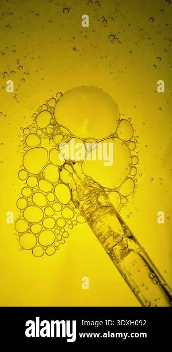 Vertical macro video of a glass pipette dropper with air bubbles in a ...