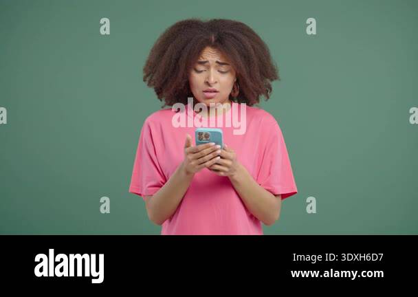 African woman scrolling phone with tired sigh. She looks bored and ...