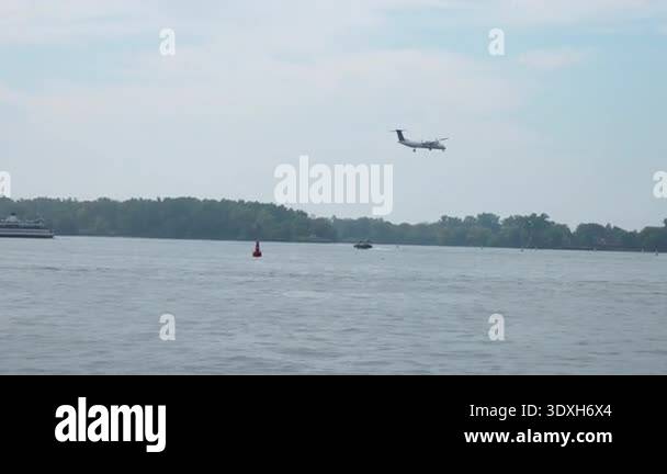 An airplane descends for a landing over a vast body of water, with ...