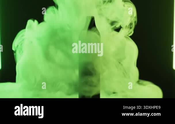 Disposable vape pen stands on a surface as thick vapor clouds swirl ...