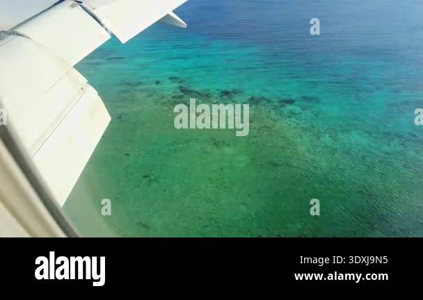 Beautiful view of airplane landing over Caribbean island coastline and ...