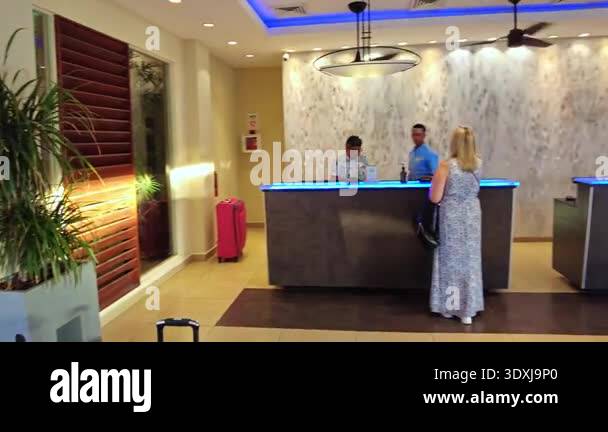 Beautiful view of hotel reception desk with guest checking in at ...