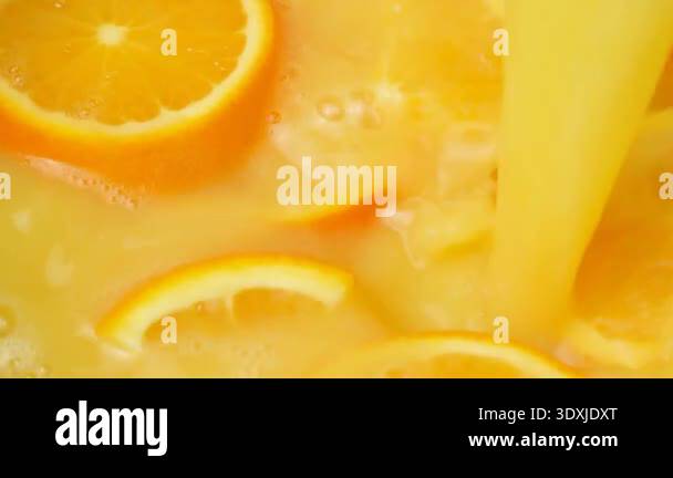 Vibrant orange juice stream drenching organic fruit, slow motion Stock ...