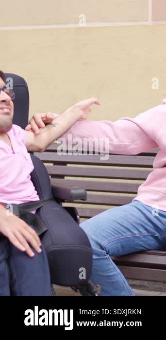 Happy people with physical disabilities socializing and smiling while ...
