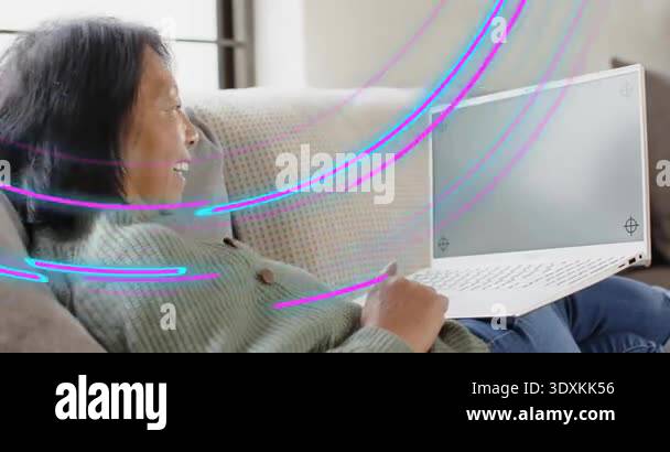 Woman placing laptop on couch tapping keyboard and hand-waving while ...