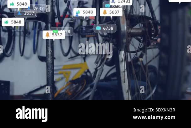 Mechanic spinning bike wheel in shop causing floating social icons ...