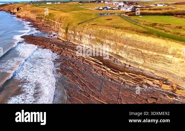Coastal landscape of green fields and limestone cliffs in Wales. Aerial ...