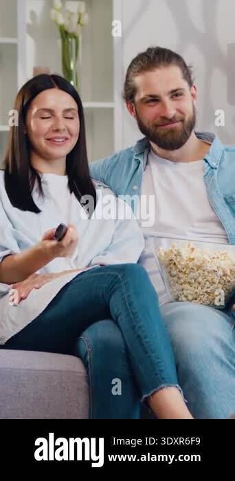 Beautiful caucasian couple of young people sitting in embrace on sofa ...