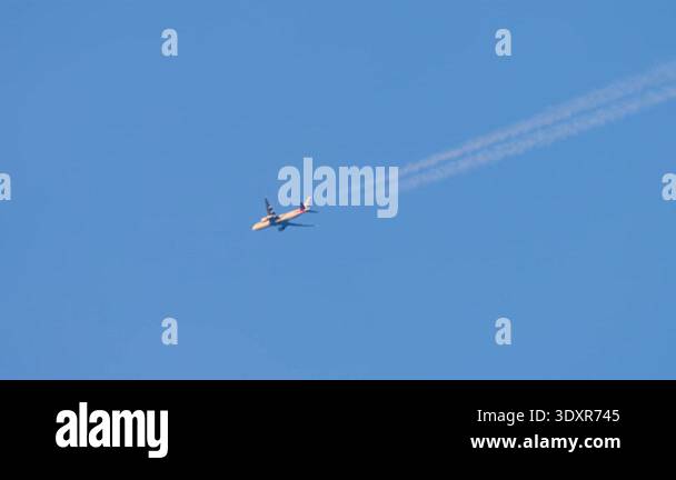 Chemtrail stretching across blue sky at high altitude. Jet airplane ...