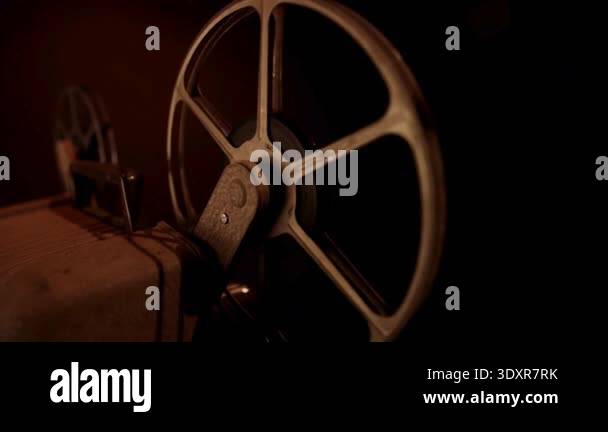 Low angle view of rotating film reel on old cinematic projector working ...