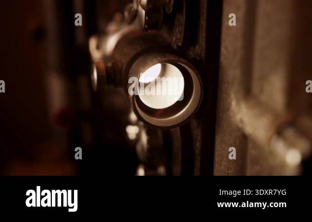 Extreme close up of a vintage film projector lens with bright light ...
