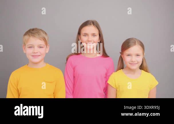 Three happy children in colorful clothes laughing out loud together ...