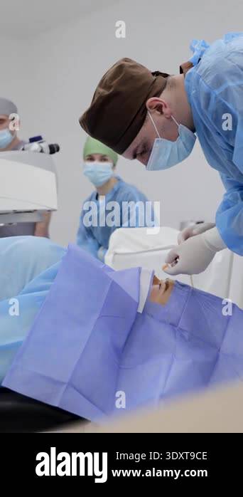 Surgeon performing an eye operation on a patient to restore sight ...