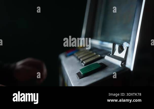 A male player plays a retro slot machine, pressing the Start and Bet ...