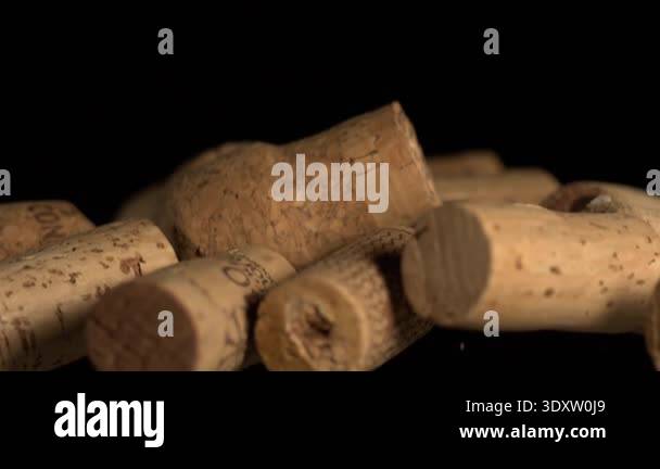 super slow motion closeup pile of wine corks on black background ...
